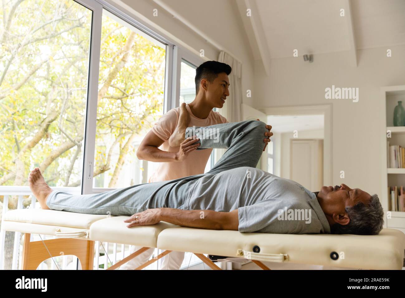 Diverse male physiotherapist advising and senior male patient ...