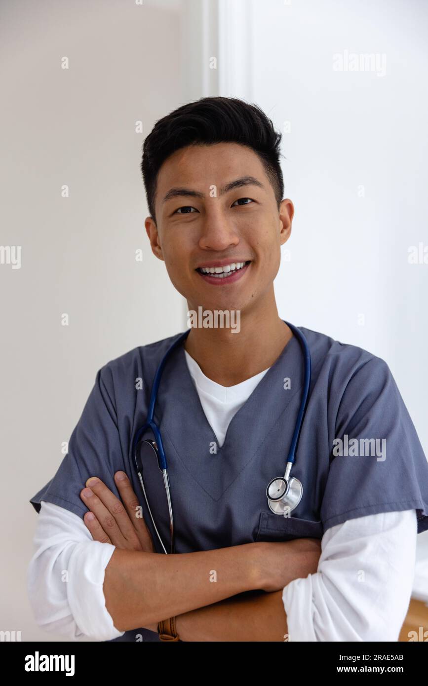 Portrait of happy asian male doctor against white wall Stock Photo - Alamy
