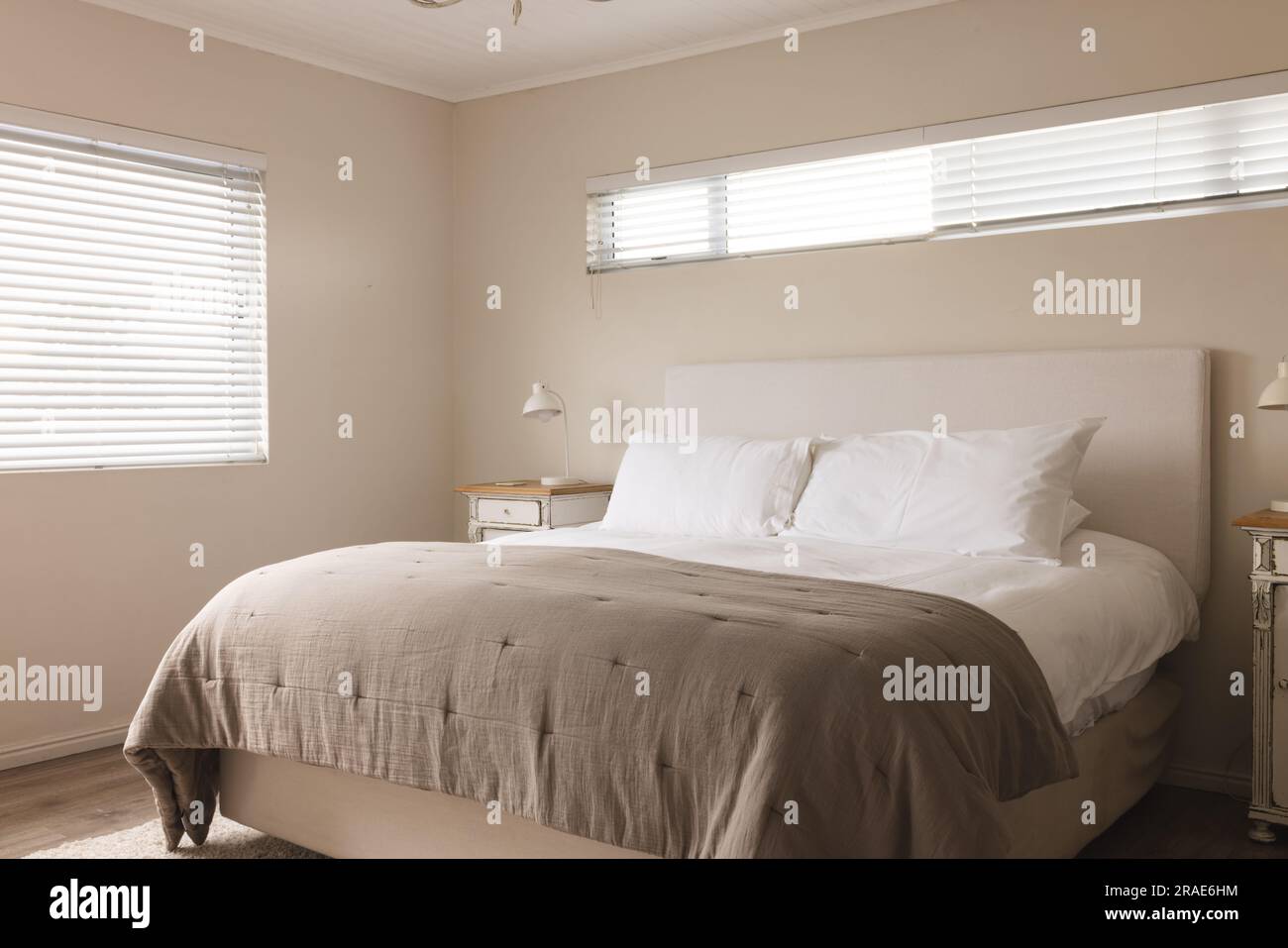 General view of bedroom with bed, bedside cabinets and windows Stock ...