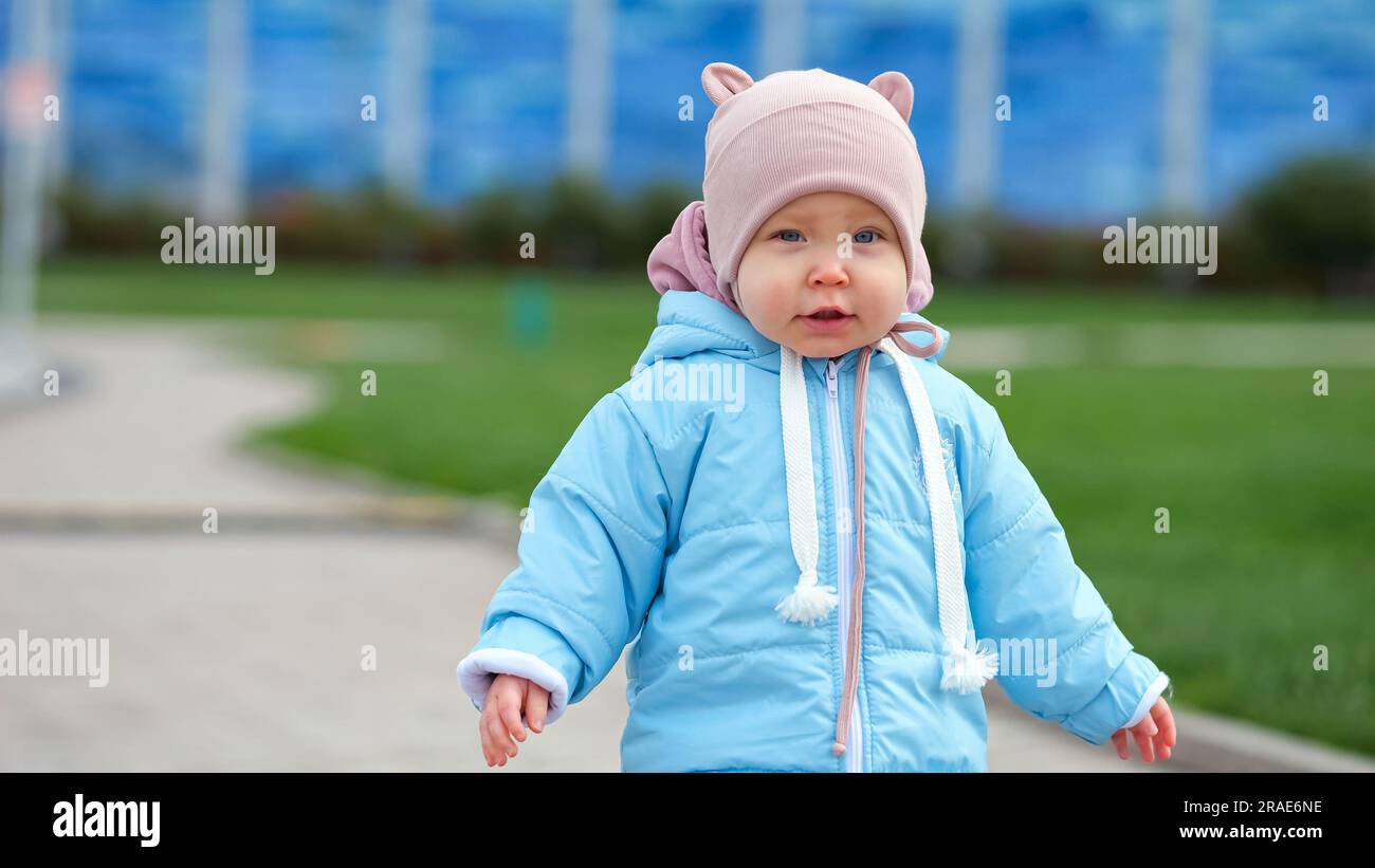 Toddler girl smiling enjoys walking alone near city stadium Stock Photo ...