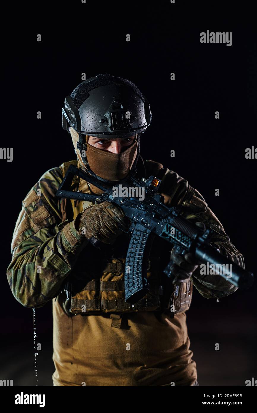A professional soldier in full military gear striding through the dark ...