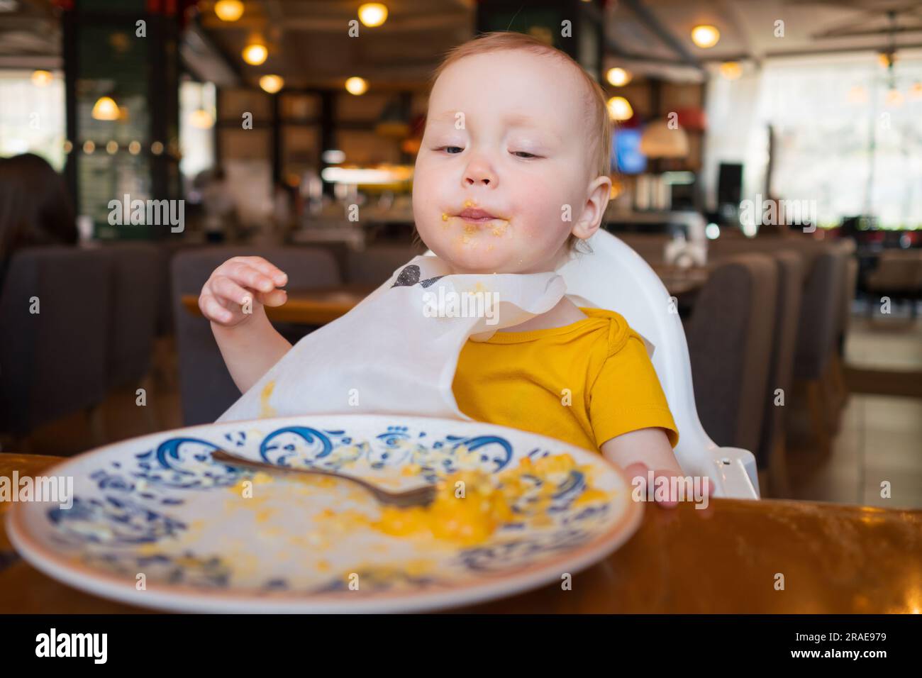 Toddler girl looking at plate likes eat meal in restaurant Stock Photo ...