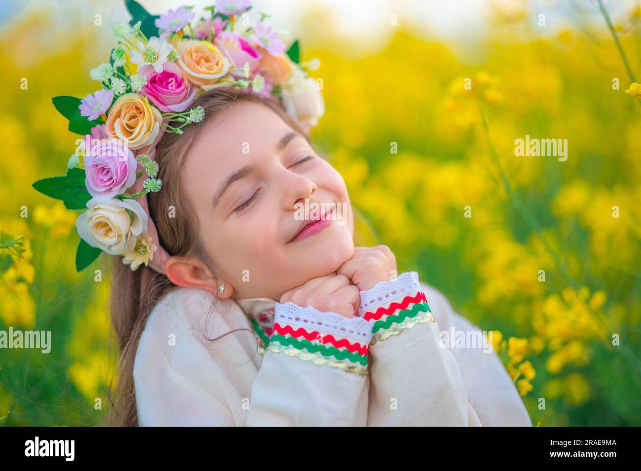 Rapeseed field and dreaming girl with flower chaplet, ethnic folklore ...