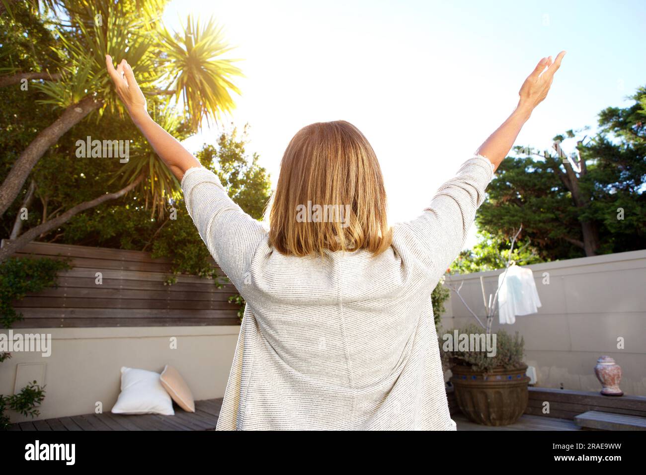 Portrait from behind of older woman with arms raised up in air Stock ...