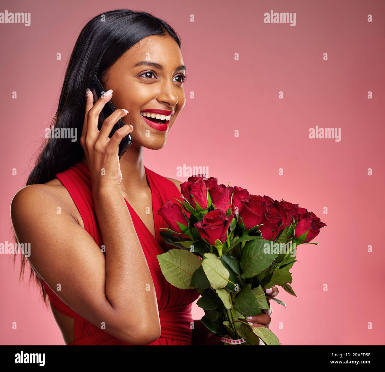 Phone call, laugh and a happy woman with roses on a studio background ...