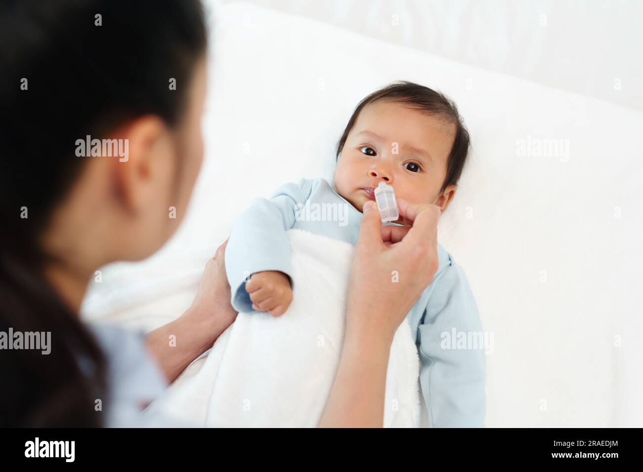 newborn baby gets nose drops by mother on a bed Stock Photo - Alamy