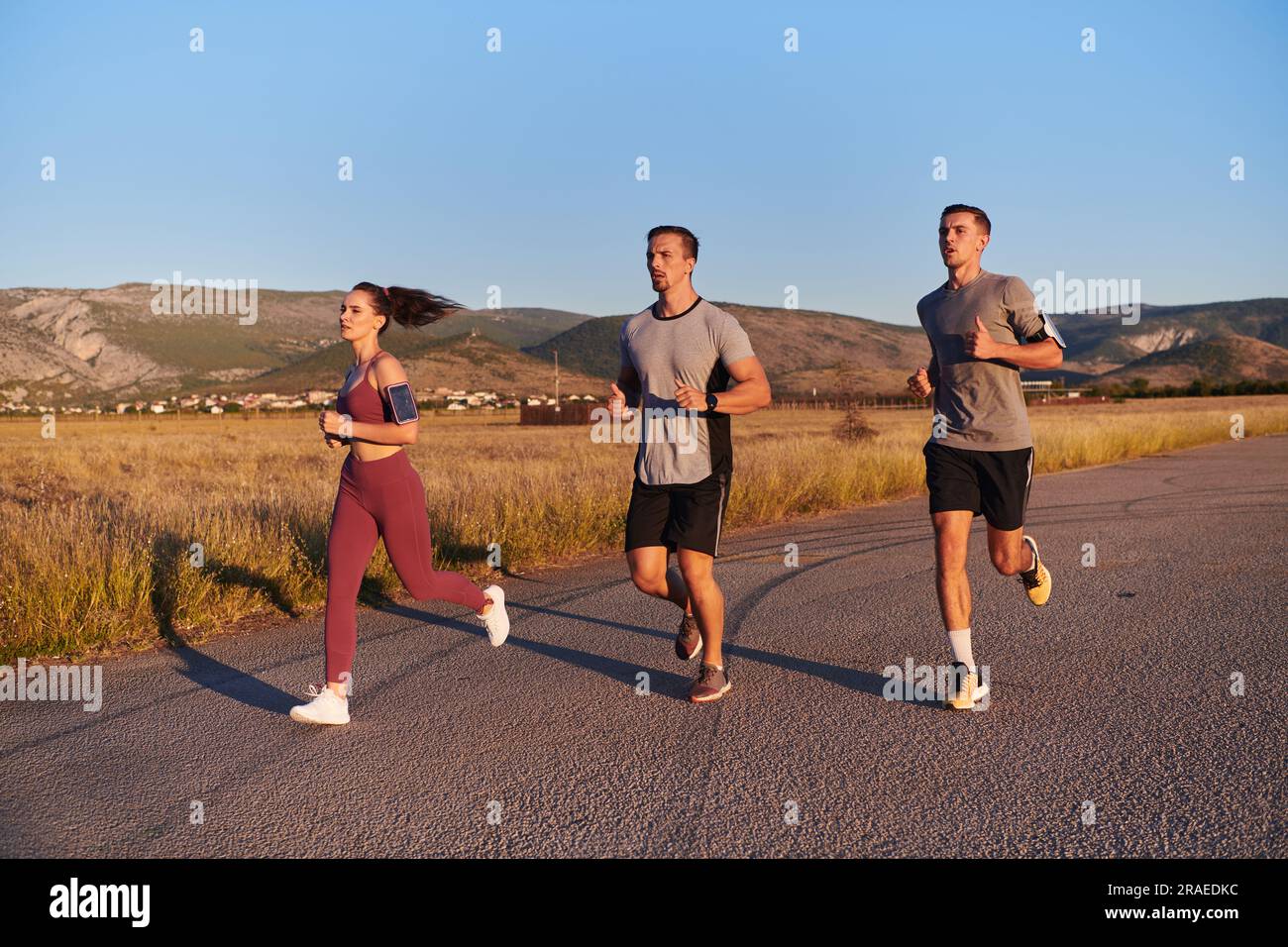 A group of young athletes running together in the early morning light ...