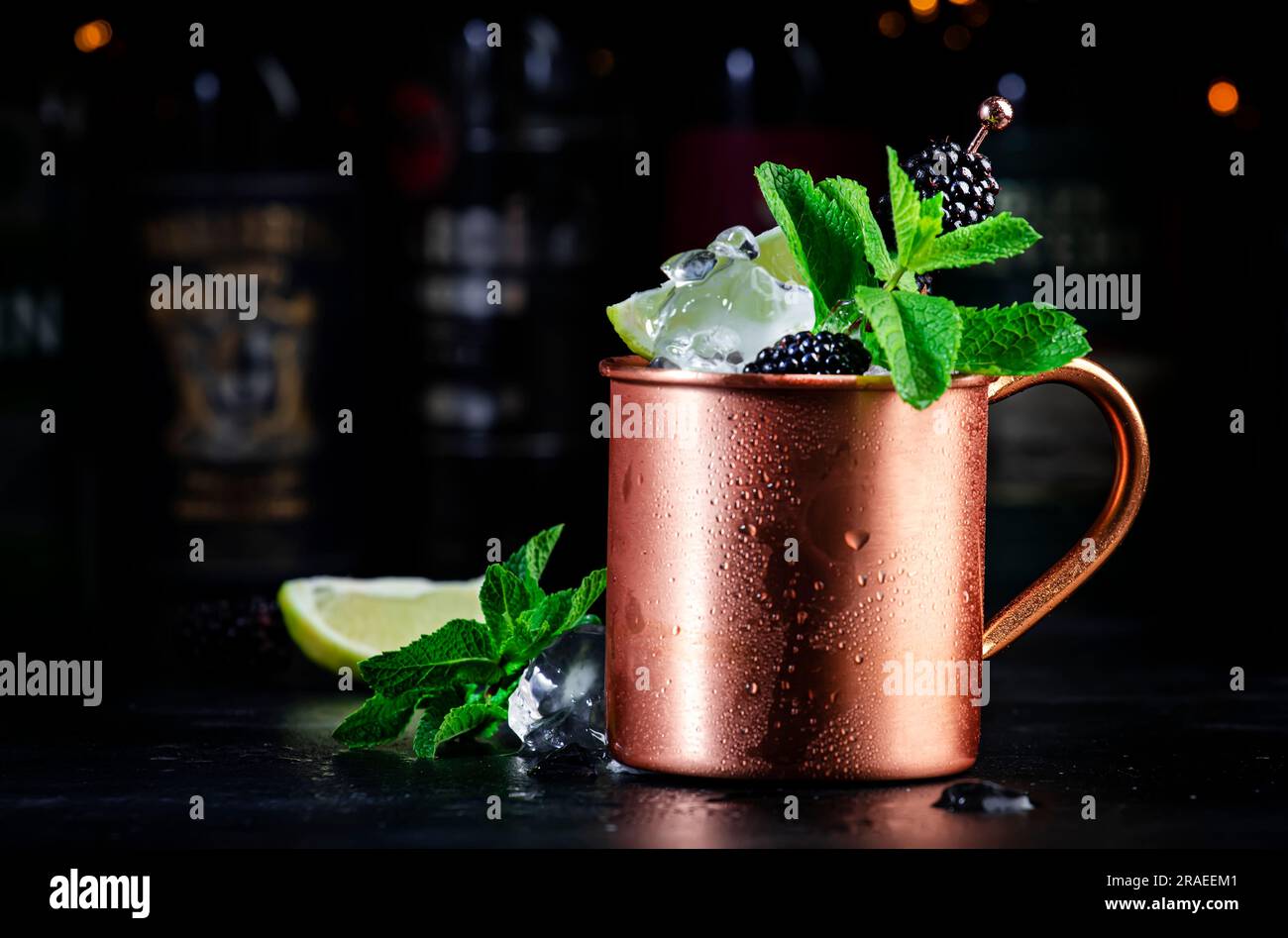 Blackberry Moscow mule alcoholic cocktail drink in copper mug with lime ...