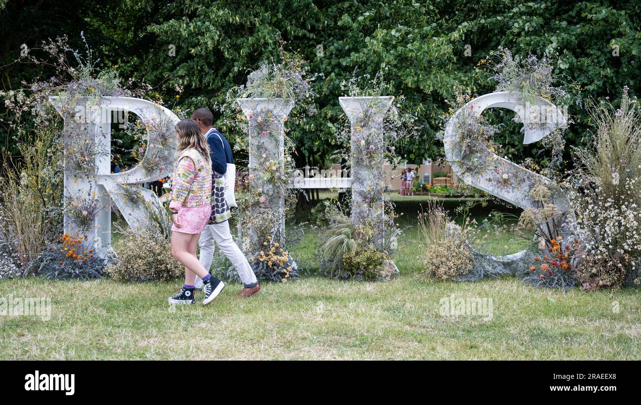 London, UK. 3 July 2023. People pass a floral RHS sign at the press ...