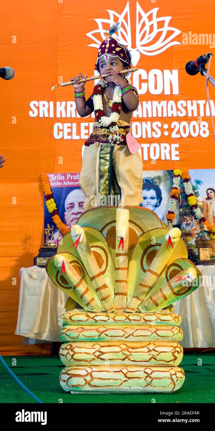 A child dressed up as lord Krishna and standing on a five headed cobra ...