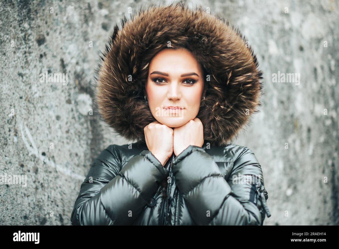 Winter portrait of beautiful woman with dark makeup, wearing warm jacket with fur hood Stock ...
