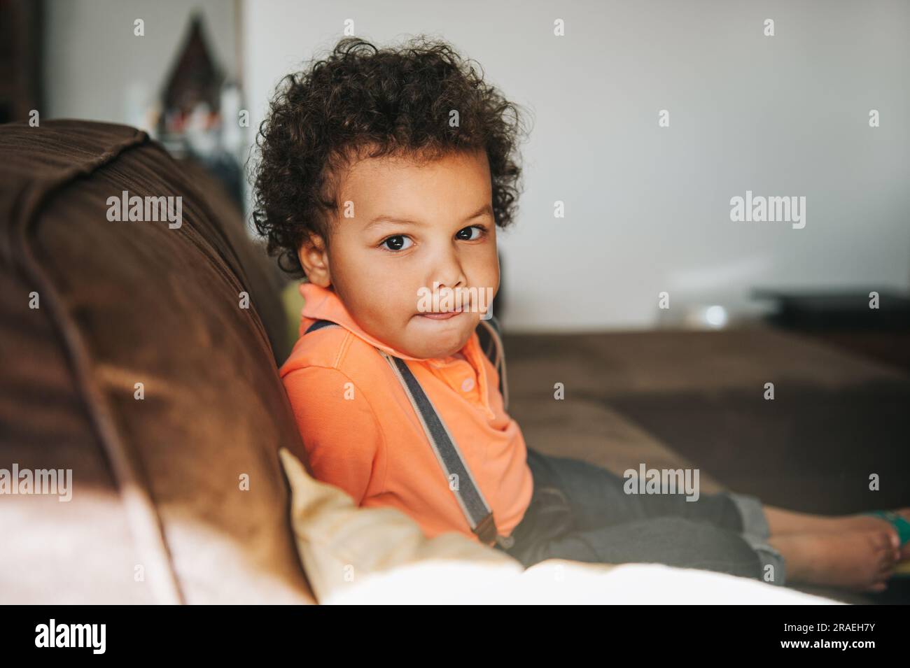 Portrait of adorable african kid boy resting on a couch Stock Photo - Alamy