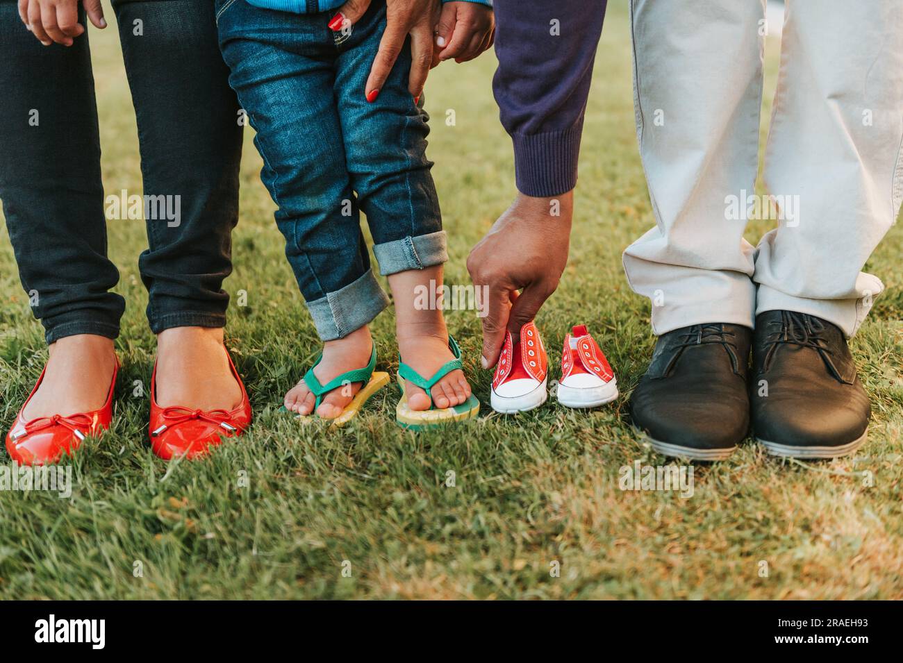 Family feet and legs posing for baby announcement Stock Photo - Alamy
