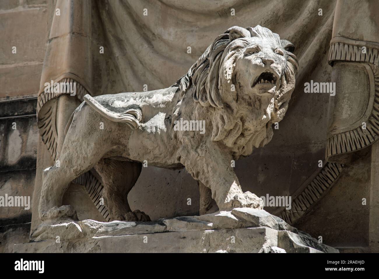 A stone lion sculpture on the wall of a building in Triq San Gwann ...