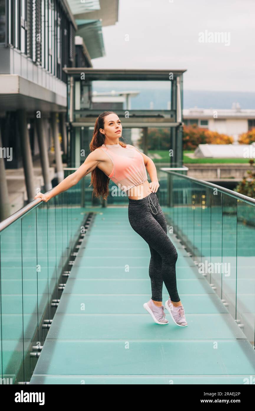 Outdoor portrait of young beautiful fit woman, wearing fashionable ...