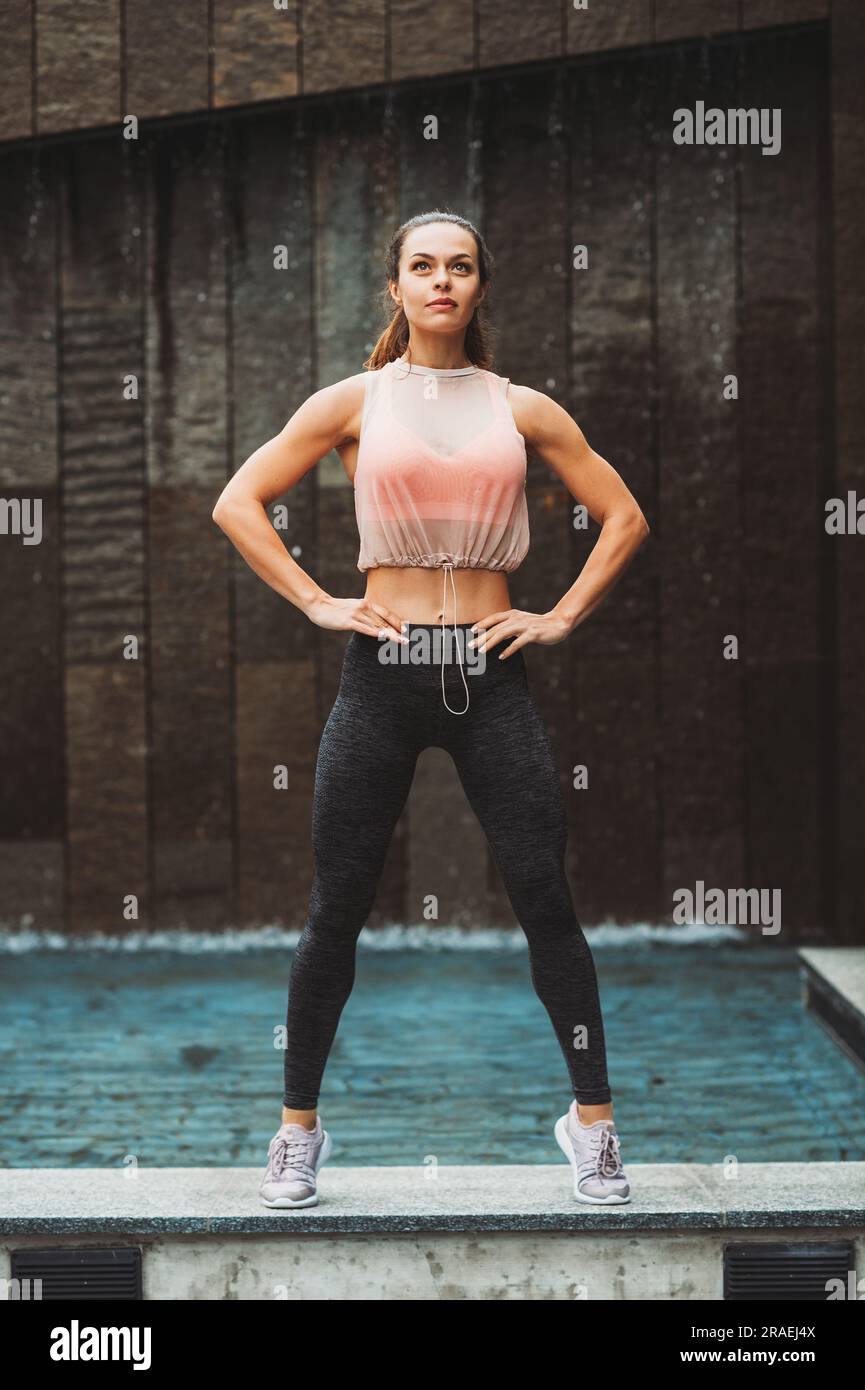 Outdoor portrait of young beautiful fit woman, wearing fashionable ...