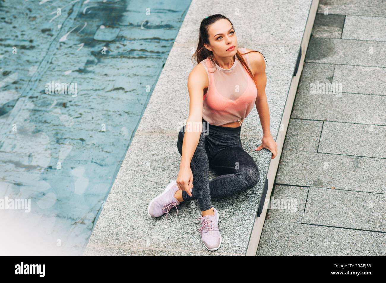 Outdoor portrait of young beautiful fit woman, wearing fashionable ...