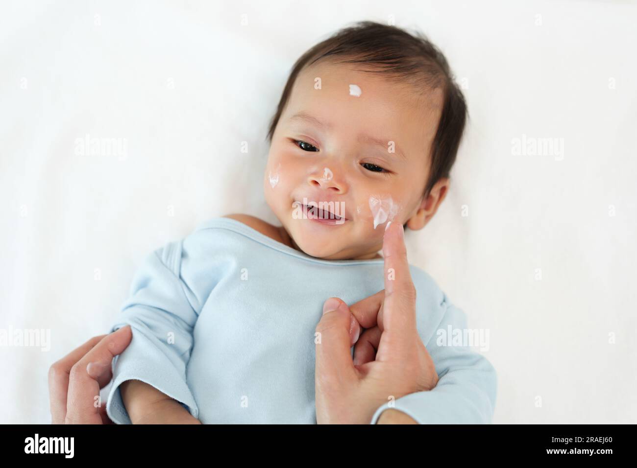 mother applying moisturizing cream on face of her newborn baby Stock ...