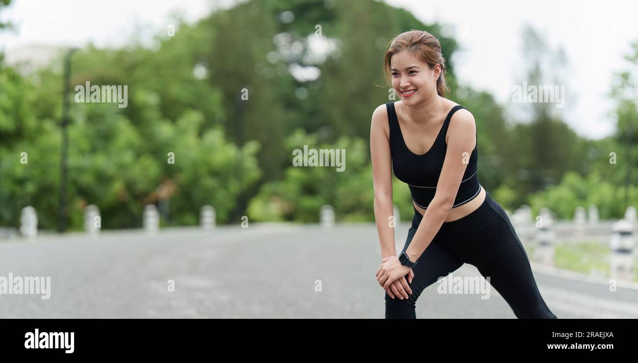 Healthy Asian woman is warm up before jogging. Fitness girl running. Female exercising at ...