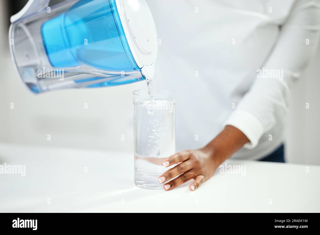 Hands, person and pitcher of filter water, glass and liquid hydration ...
