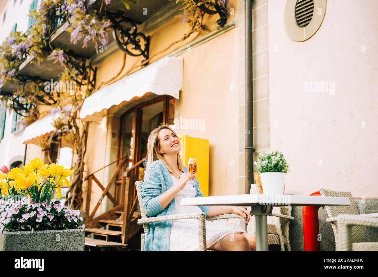 Outdoor portrait of pretty young woman resting in beautiful cafe on a ...