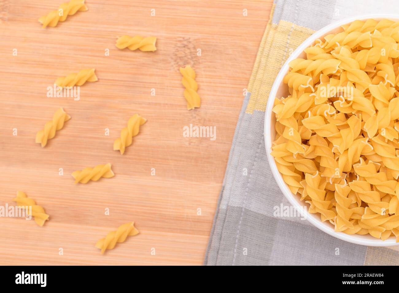 Uncooked Fusilli Pasta in White Bowl on Wooden Board. Raw and Dry ...