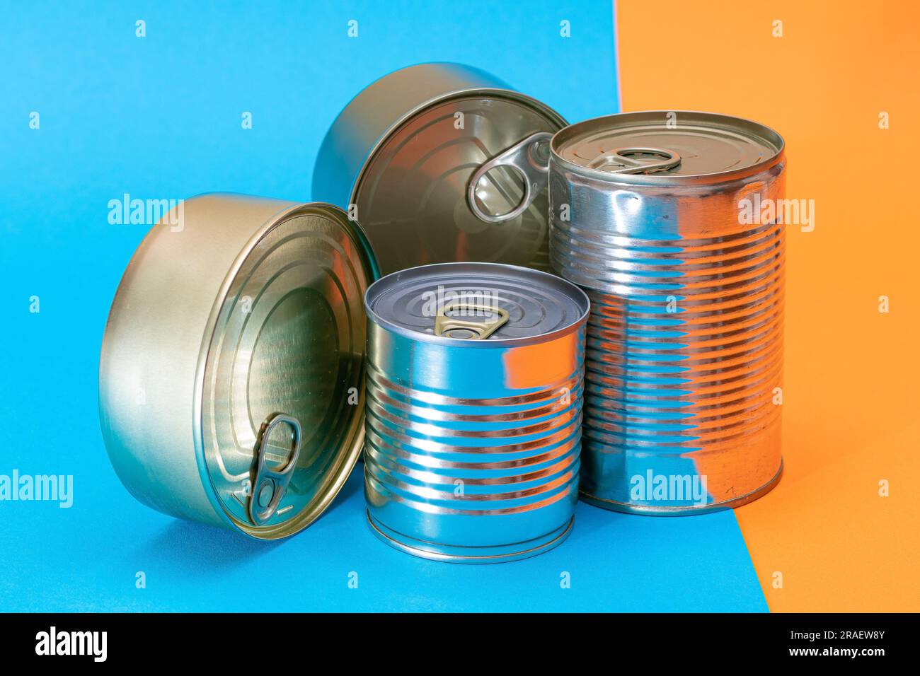 A Group of Stacked Tin Cans with Blank Edges on Split Blue and Orange ...
