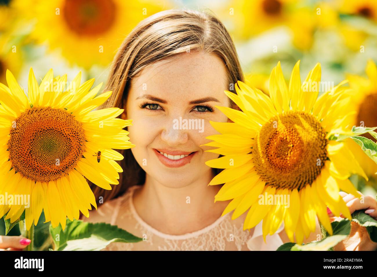 Outdoor portrait of beautiful young woman with sunflowers, health and ...