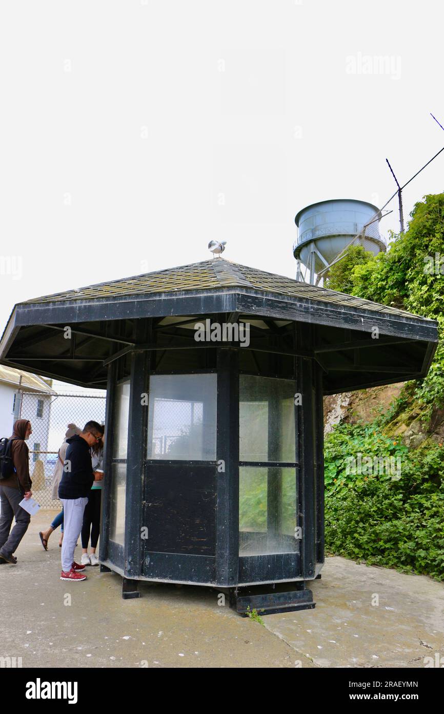 Tourists looking at a small hut with the water tower behind Alcatraz ...