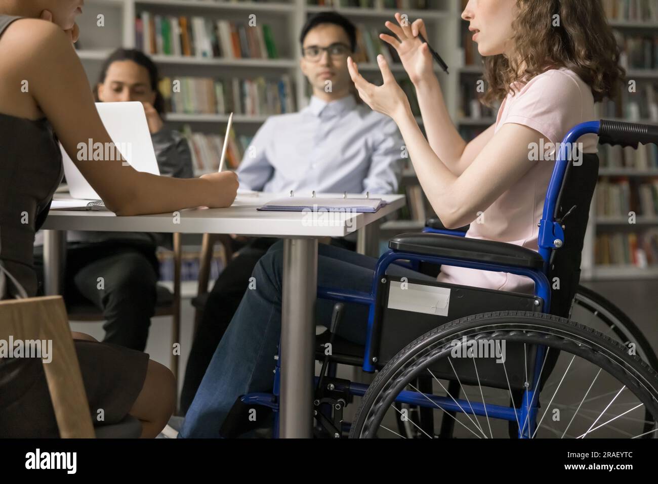 Team of students and speaker with disability meeting in library Stock ...