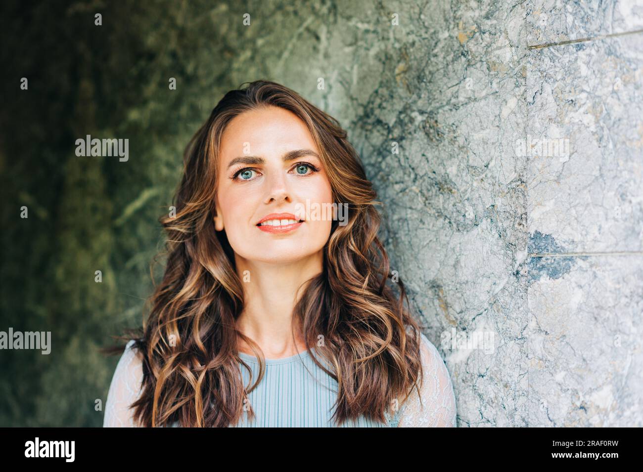 Outdoor Portrait Of Beautiful Woman With Curly Hair Wearing Blue Dress