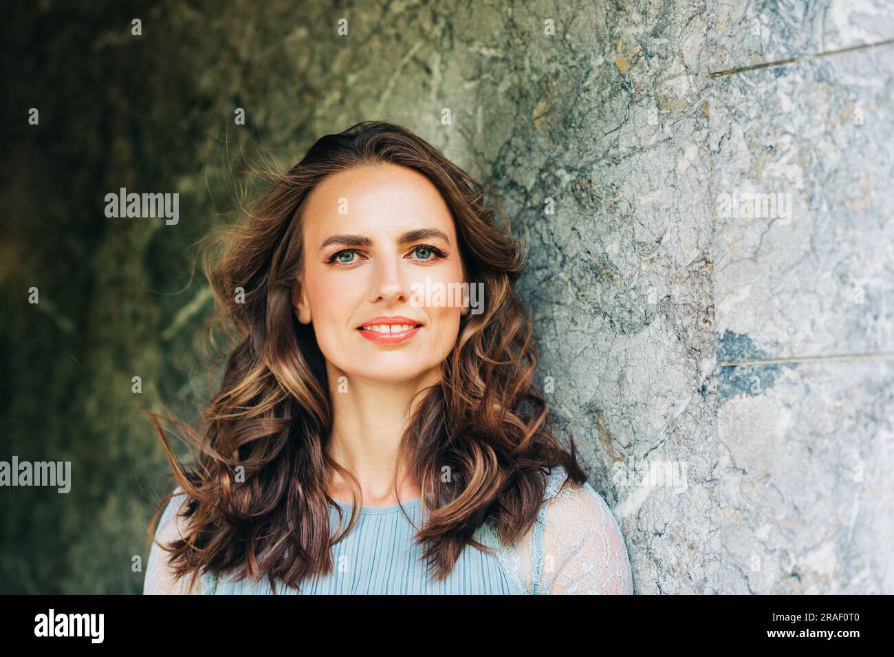 Outdoor Portrait Of Beautiful Woman With Curly Hair Wearing Blue Dress