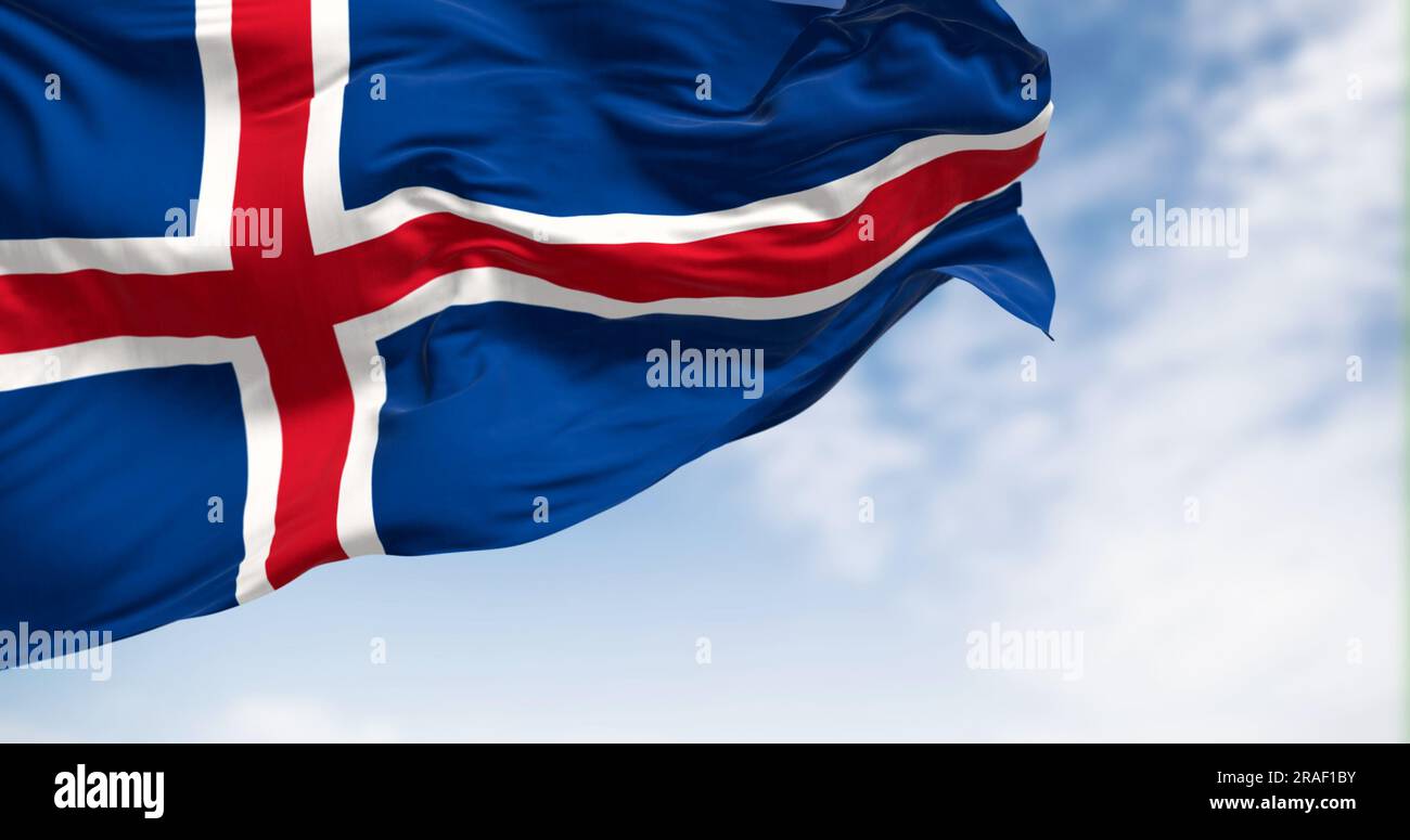 Iceland national flag waving in the wind on a clear day. Blue flag with ...