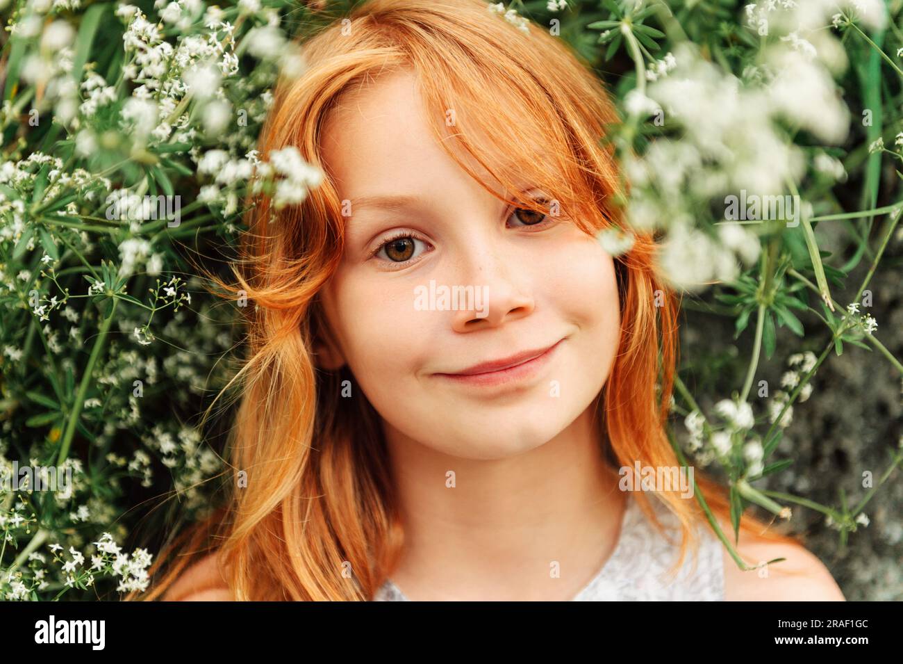 Outdoor portrait of pretty young kid girl posing outdoors, standing ...