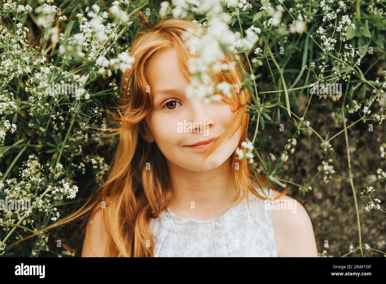 Outdoor portrait of pretty young kid girl posing outdoors, standing ...