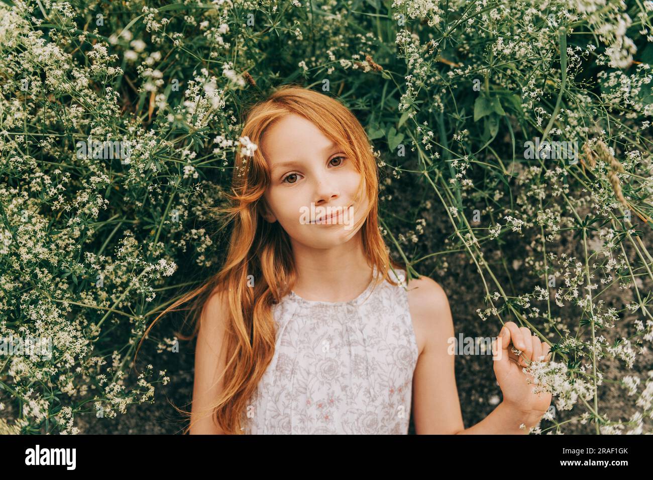 Outdoor portrait of pretty young kid girl posing outdoors, standing ...