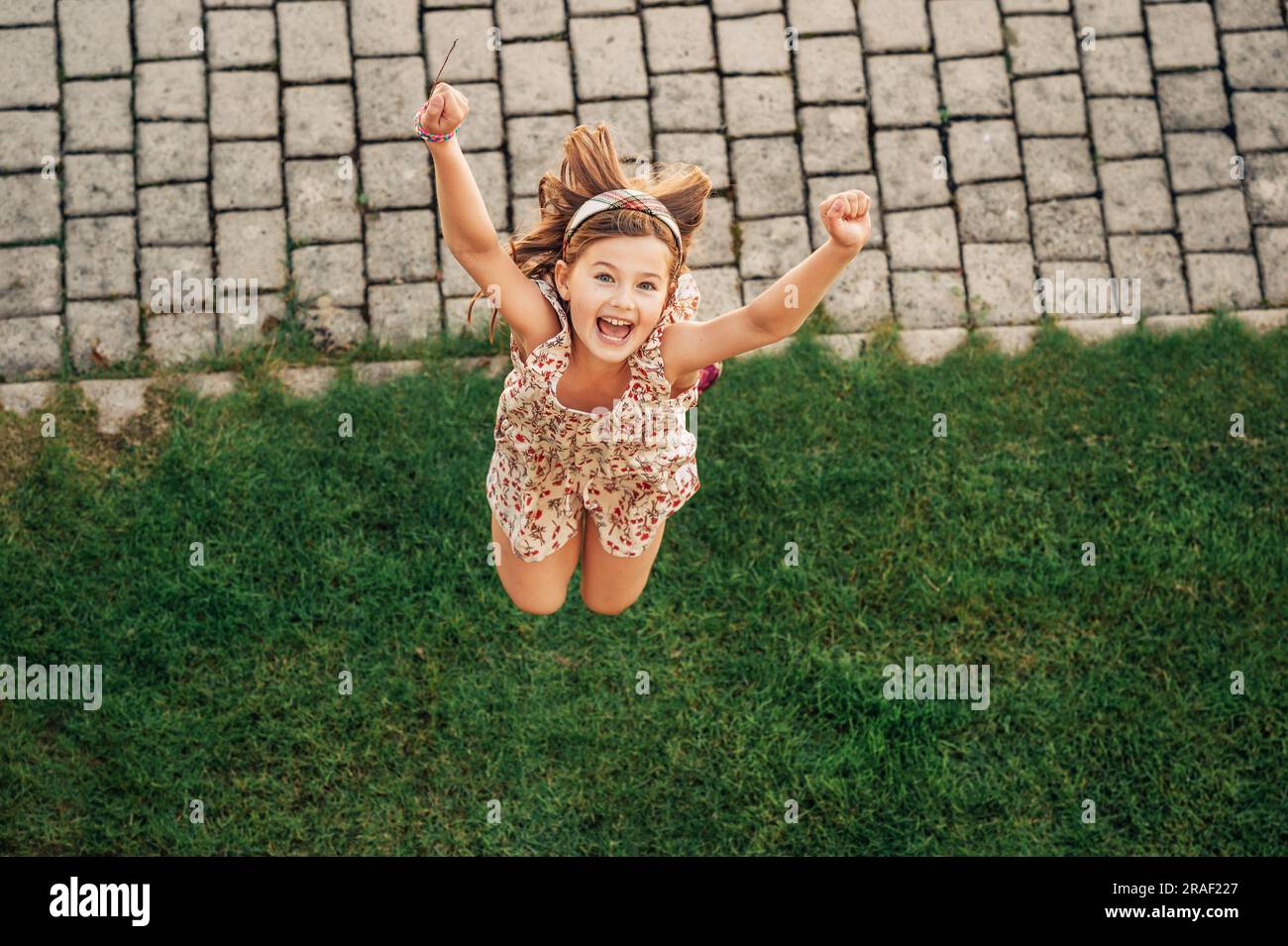 Happy young kid girl playing in summer park, jumping, top view Stock ...