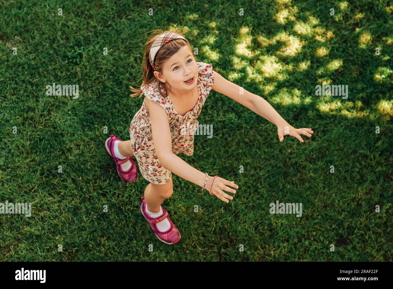 Happy young kid girl playing in summer park, catching something, top ...