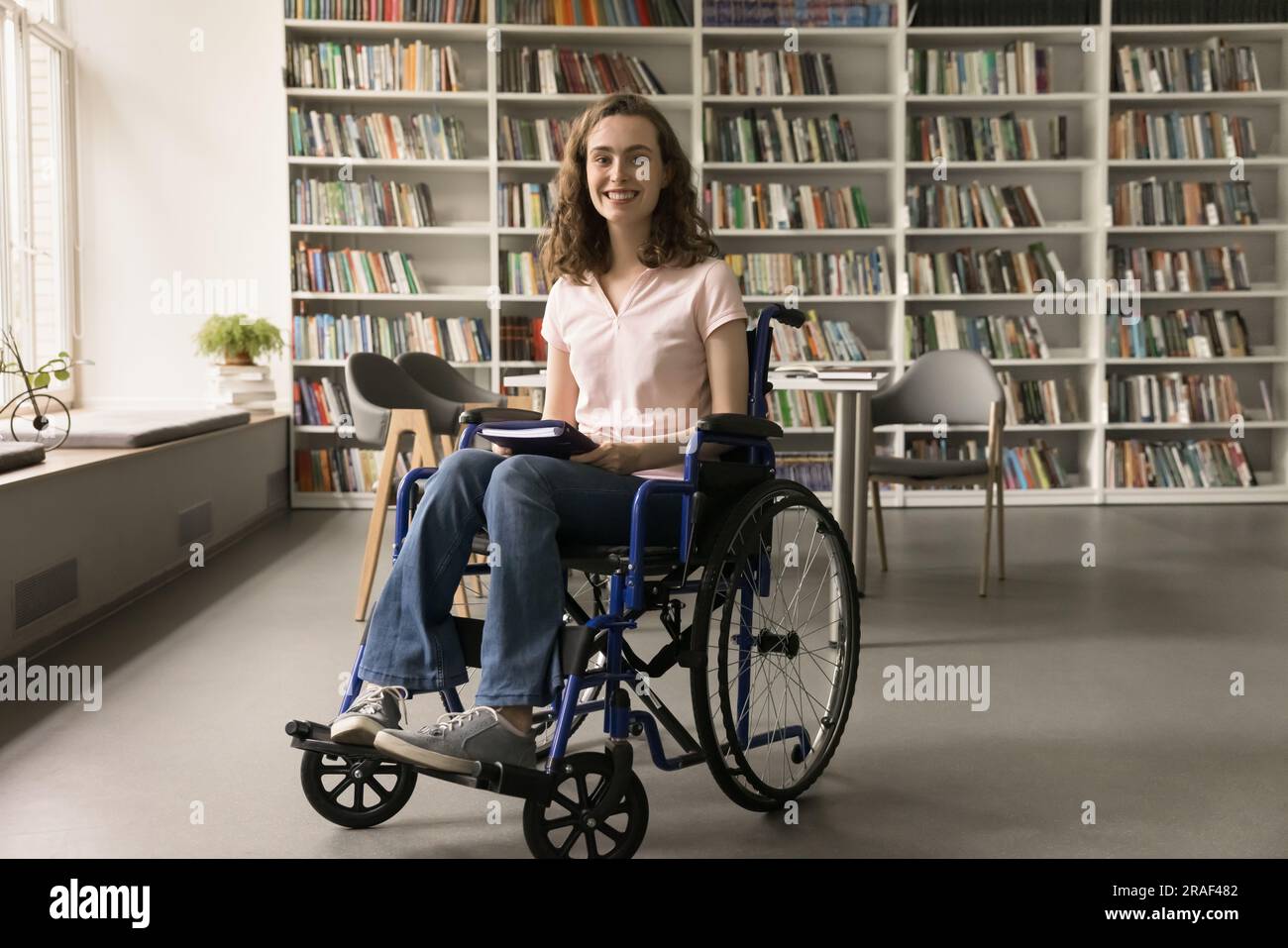 Cheerful young college student with disability using wheelchair Stock ...