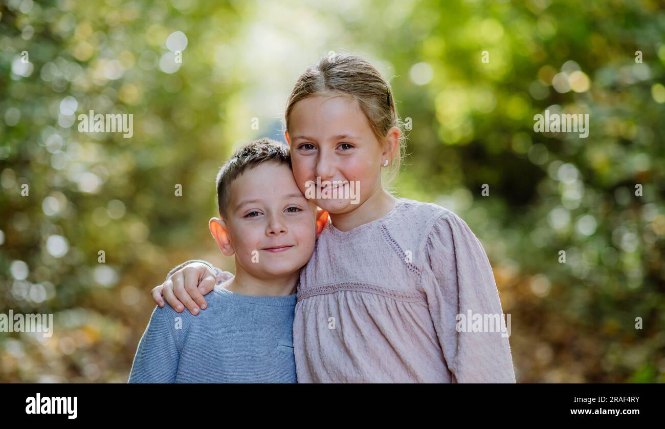 Portrait of little children, siblings, hugging in forest Stock Photo ...