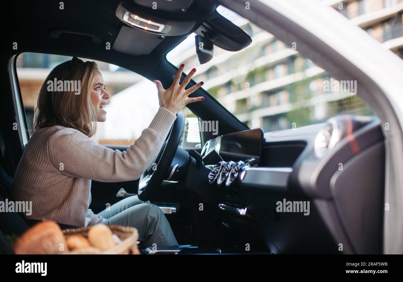 Upset woman driving her car in a city Stock Photo - Alamy