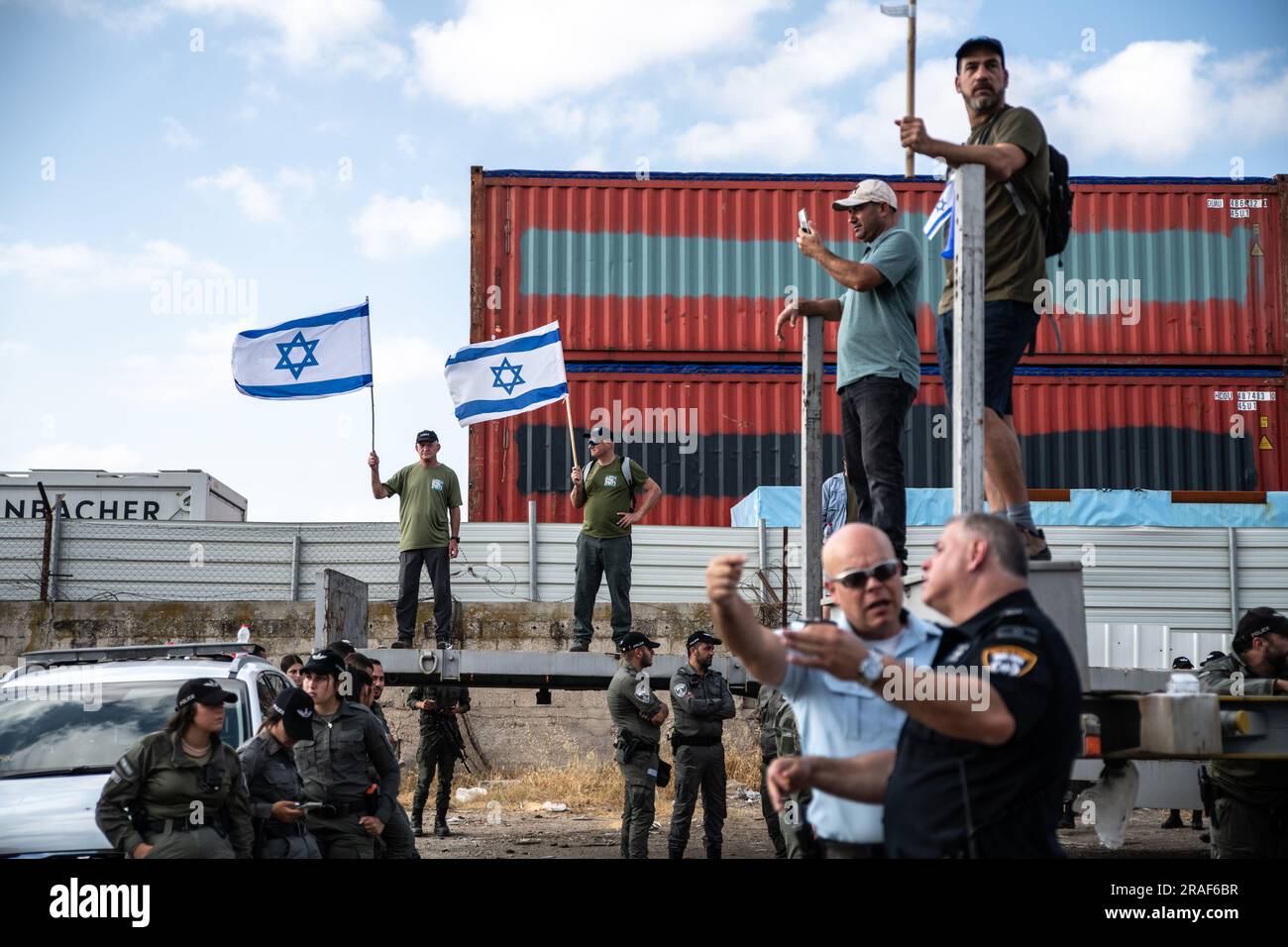 Israeli protestors wave the Israeli flag next to Israeli police and ...