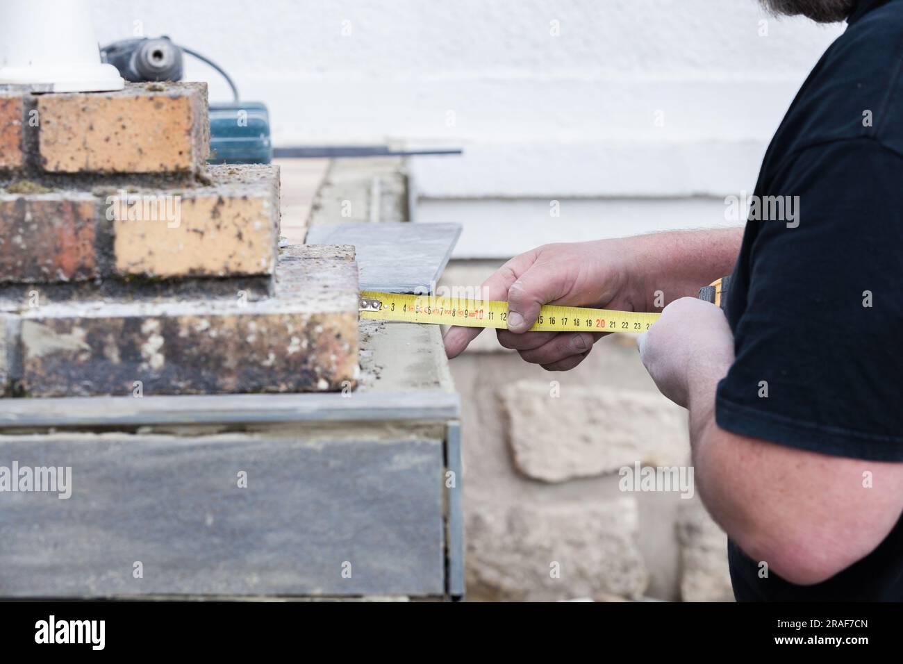 the tiler measures and puts marks to cut and lay a tile Stock Photo - Alamy