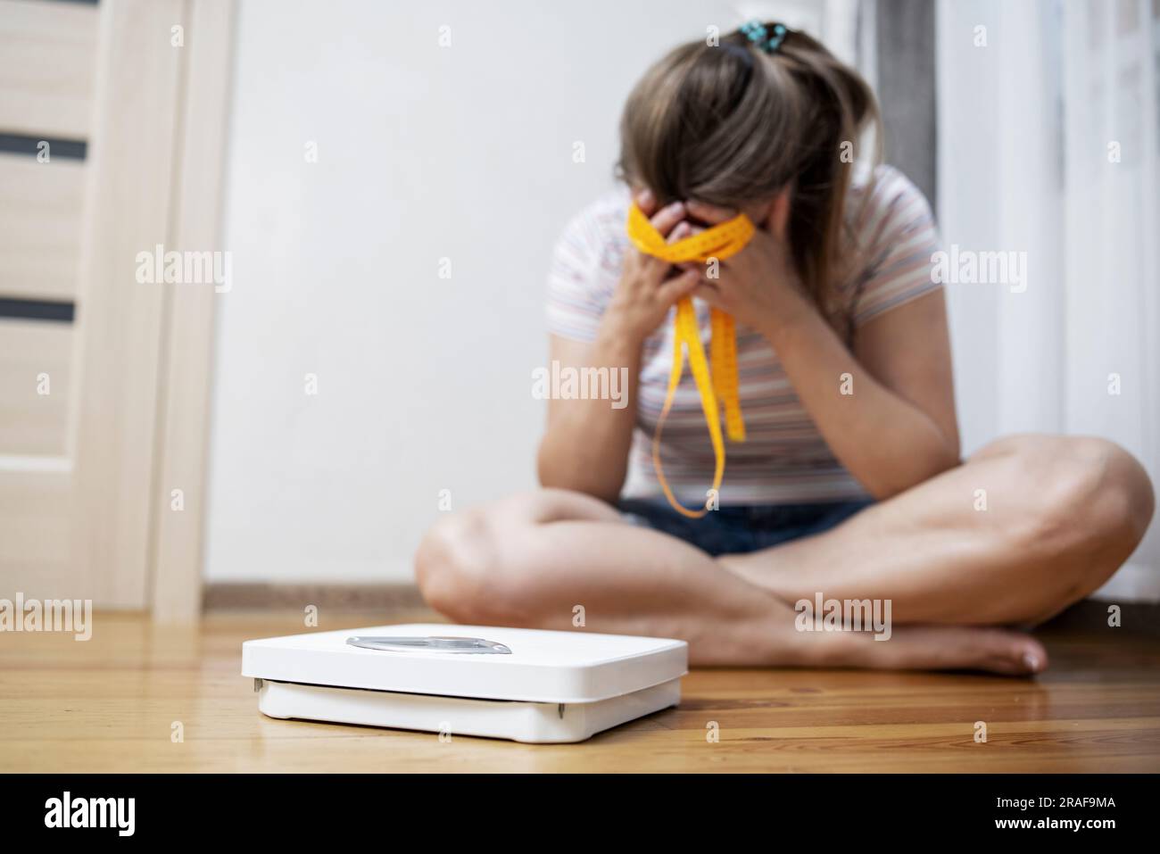 White scale and depression, upset and sad woman with measuring tape on ...