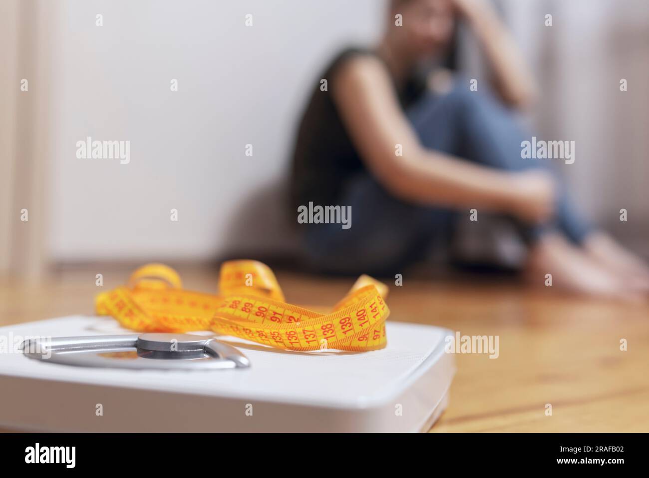 White scale and depression, upset and sad woman with measuring tape on floor Stock Photo - Alamy
