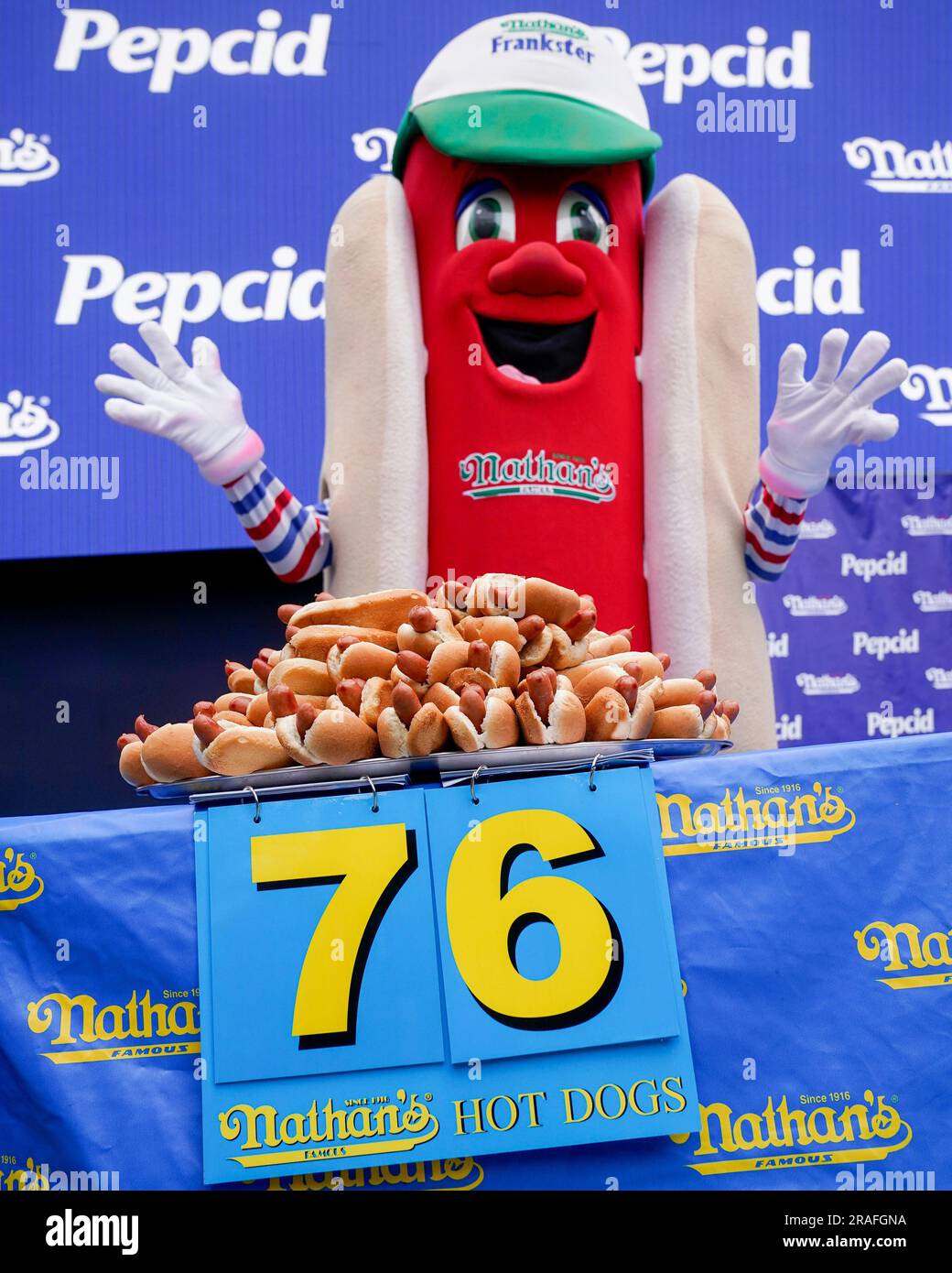 Prankster, the Nathan's Famous mascot, dances beside a table loaded ...