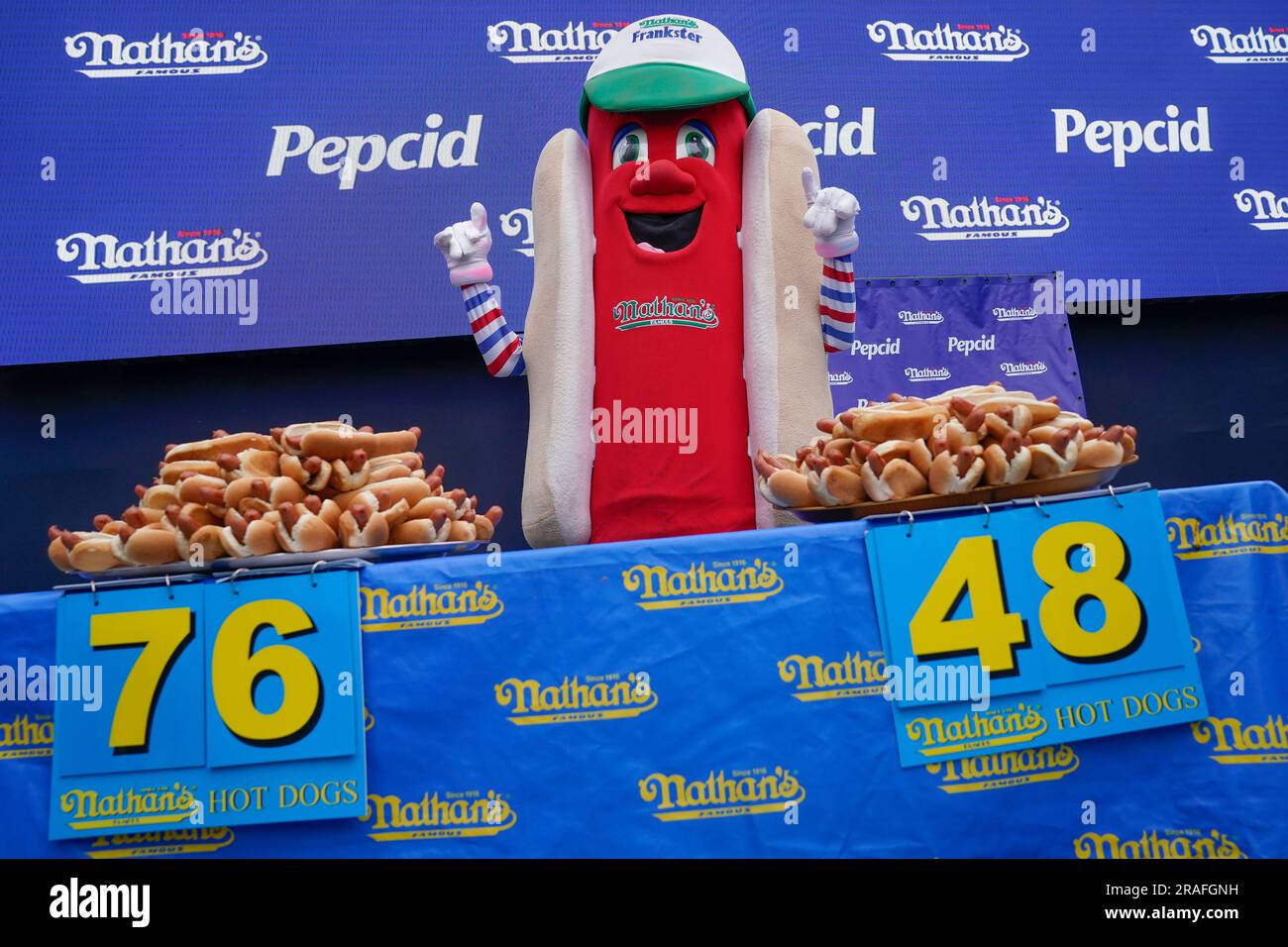 Prankster, the Nathan's Famous mascot, dances beside a table loaded ...