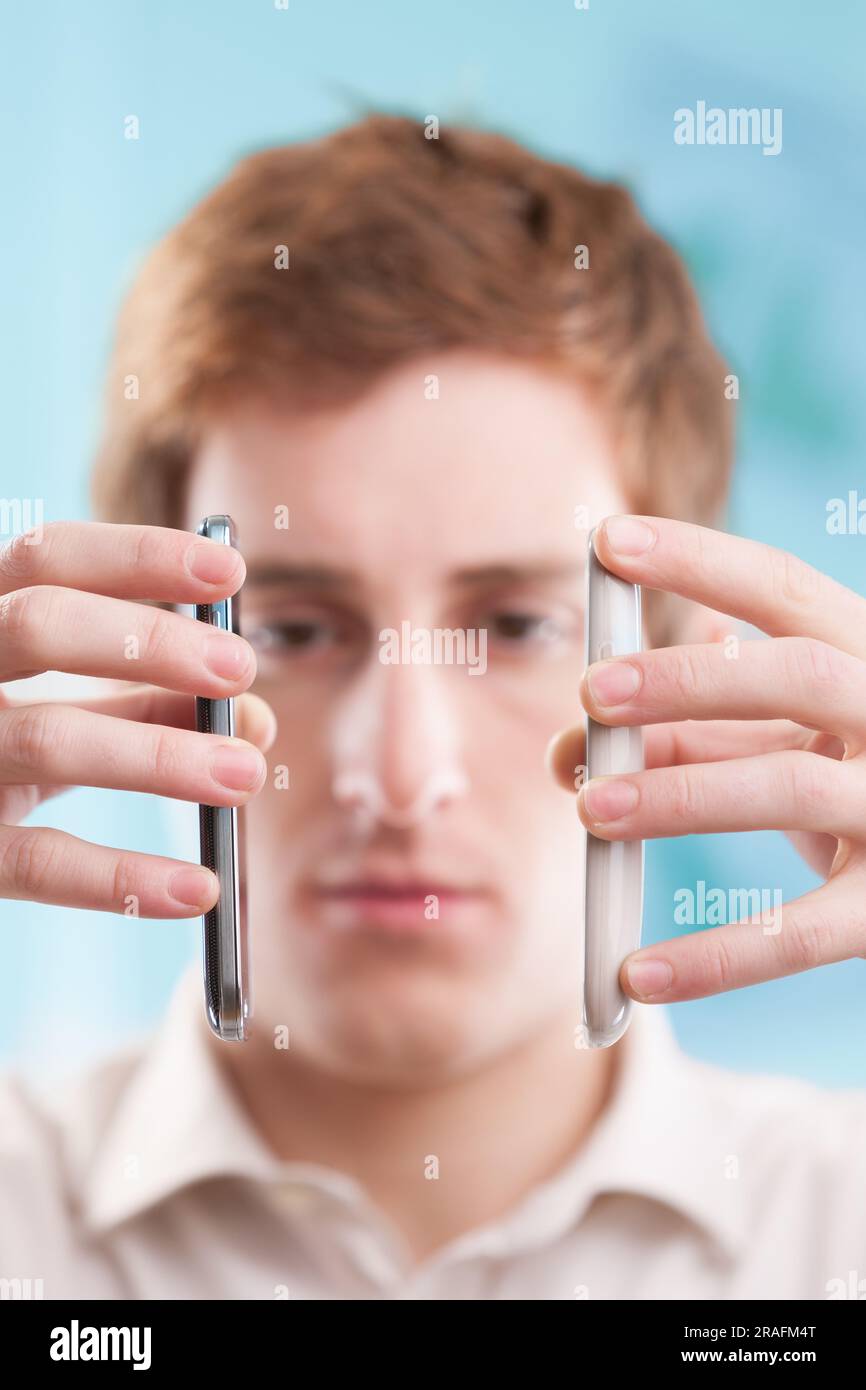 In focus hands holding two smartphones with screens facing each other ...