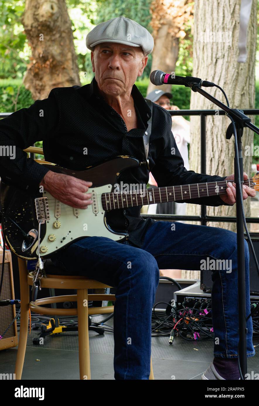 Guitarist and singer sitting down in front of a microphone on stage in ...