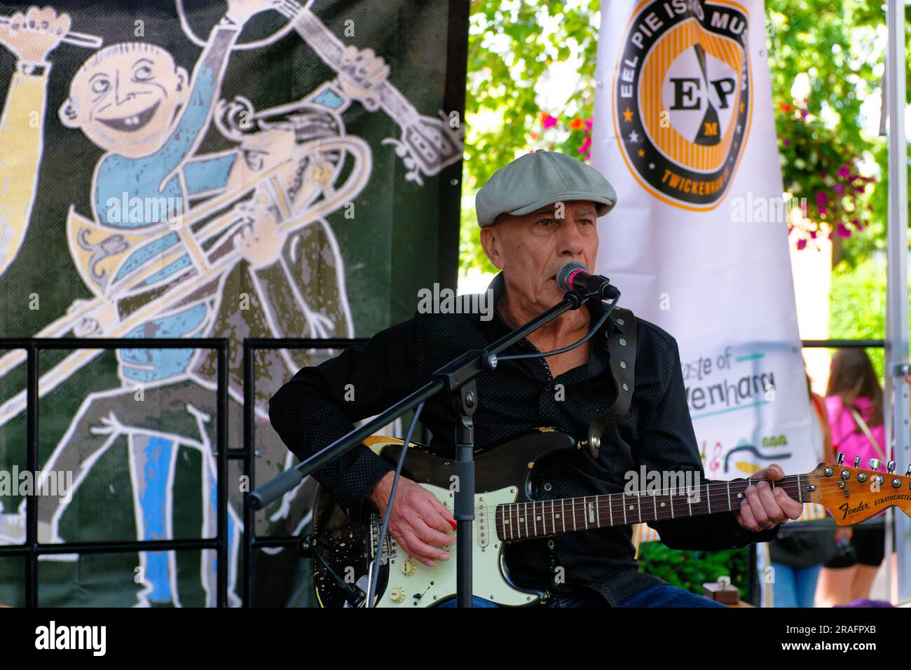 Guitarist and singer sitting down in front of a microphone on stage in ...